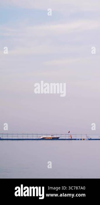 Pier, red sea is calm, windless weather, there are clouds in the sky ...