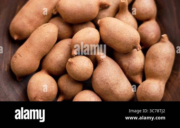 Tropical tamarind fruits in wooden bowl. Tamarindus indica pods. Top ...