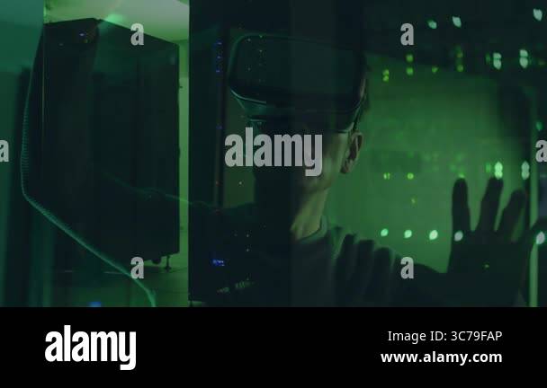 Wearing VR headset, person interacting with animation in green-lit room ...