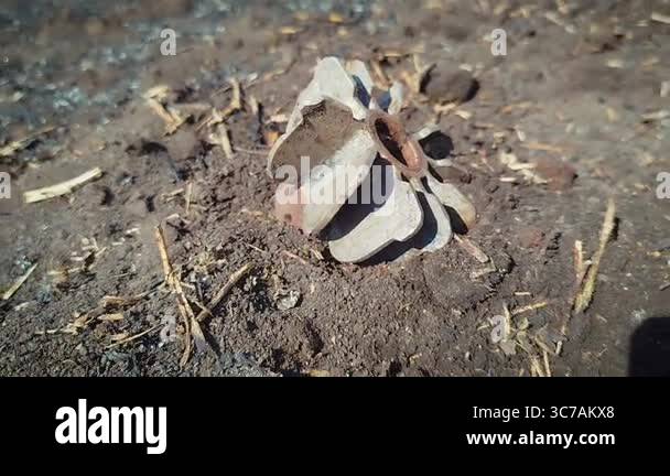 The tail of the mortar shell sticks out of the ground. An unexploded ...