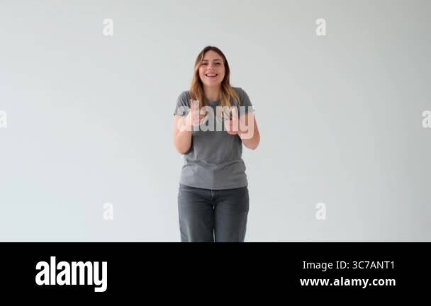 Happy and optimistic Caucasian young woman showing thumb up gesture and ...