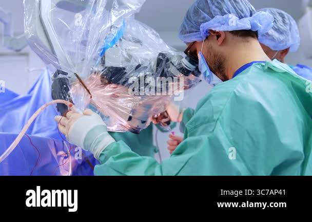 Doctor in glasses looks into microscope binoculars. Surgeon applies ...