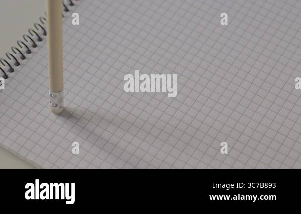 Paper notepad on table , tapping pencil on black page waiting for ...