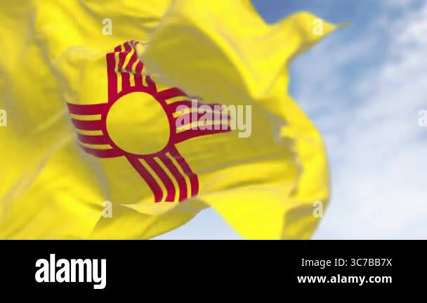 The flag of New Mexico waving, showing the red Zia sun symbol on a gold ...