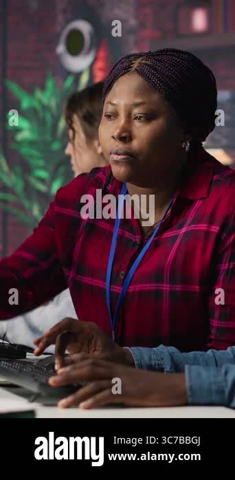 Vertical video Call center manager teaching intern how to use AI to ...
