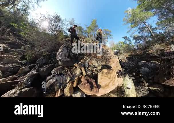 Wide-Angle View of Two Hikers Climbing Over Rocky Terrain in a Mountain ...