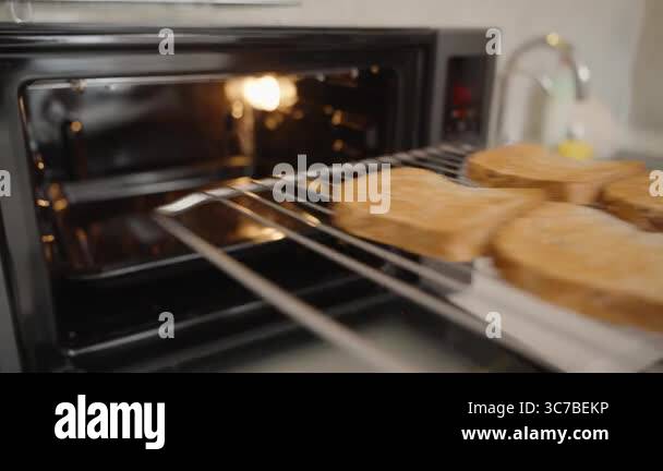 Person Wearing Oven Mitts Removing Slices of Toasted Bread from Hot ...