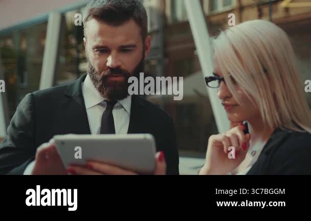 Close up business man and woman use tablet computer together at outdoor ...