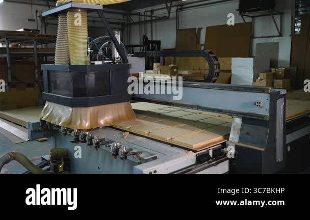 Automated CNC machine precisely cuts wooden sheet into multiple ...