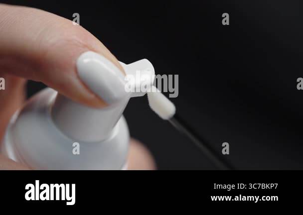 Close-up of a person dispensing a white foam from a pump bottle against ...