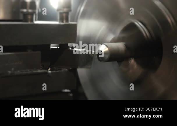 A lathe processes an iron workpiece in a workshop. A metal cutting ...