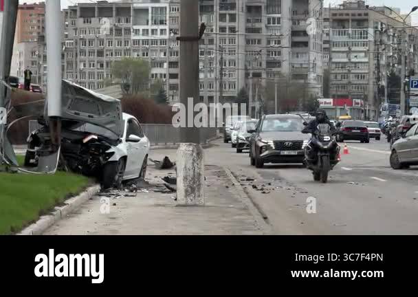 A heavily damaged white sedan after an accident on a city road. The car ...