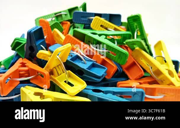 A pile of multi color plastic laundry clips rotating on the white ...