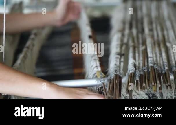 Close-up of woman's hands weaving yarn, silk thread and woven by using ...