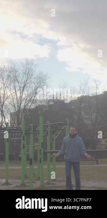 A man uses fitness equipment in a beautiful outdoor park, surrounded by ...