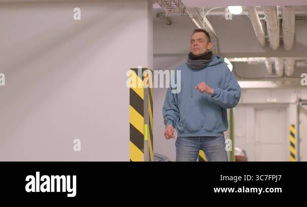 A cautious man walks through an industrial area where there are many ...