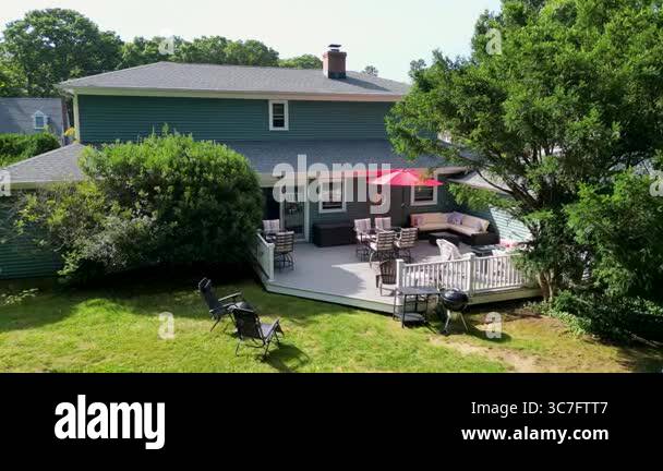 Drone moving closer to a residential backyard deck set up for a party ...