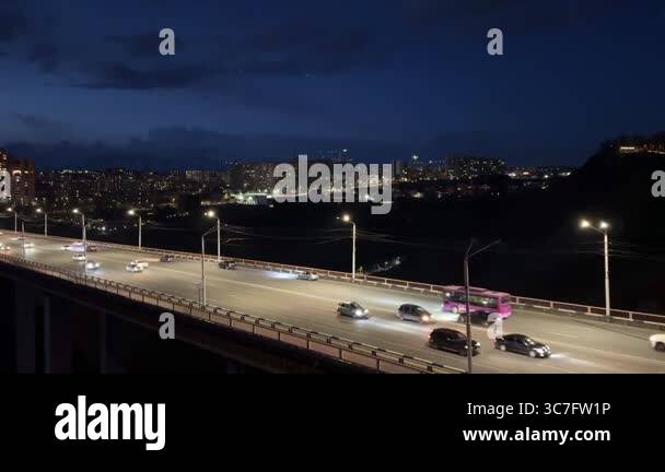 Night view of the city with a view of the bridge and cars passing along ...