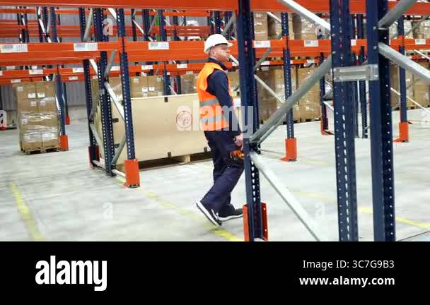 Warehouse worker operating a retractable racking system, optimizing storage space and improving ...