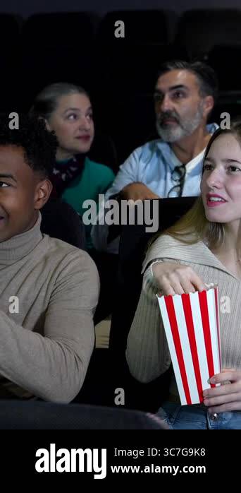 People of different ages enjoy a 3d movie experience, eating popcorn ...