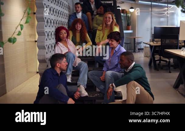 Office workers gathering on stairs, engaging in lively conversation and ...