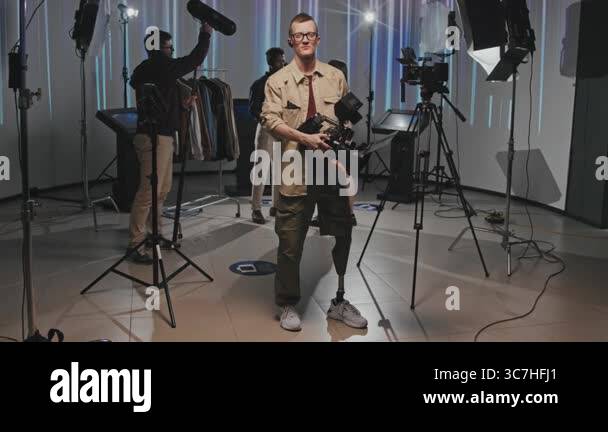 Slowmo full-shot portrait of young cameraman with prosthetic leg ...