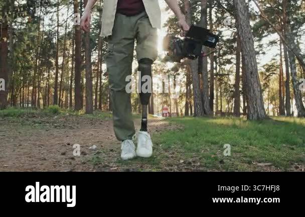 Low-section slowmo of unrecognizable cameraman with prosthetic leg ...