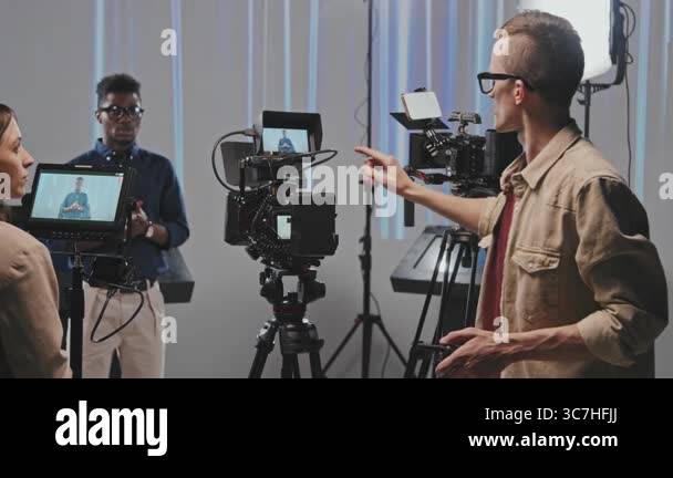 Medium rear-view PAN slowmo of cameraman and his team organizing ...