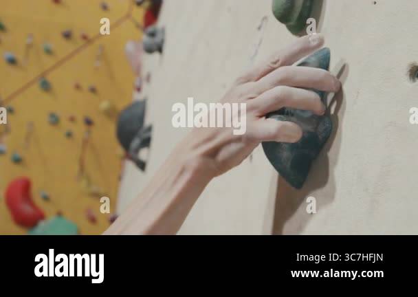 Close-up of male athlete practicing indoor wall climbing in modern ...