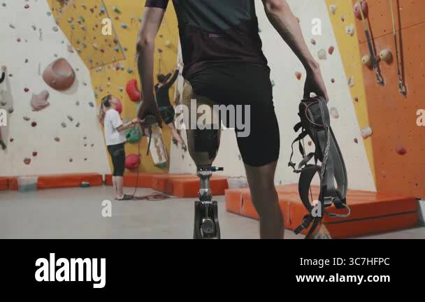Medium slowmo of sportsman with leg prosthesis holding safety equipment ...