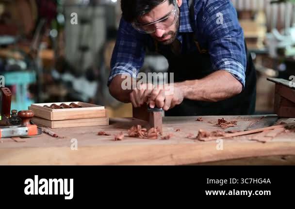 Luthier making wooden musical and using traditional tools in workroom ...