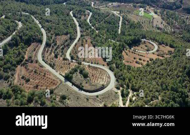 Incredible aerial view of a winding rural road full of perfect curves ...