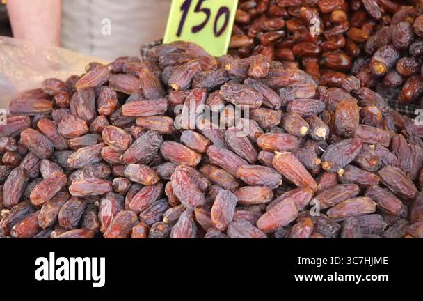 Customers browse ripe dates for sale at busy market stall today Stock ...