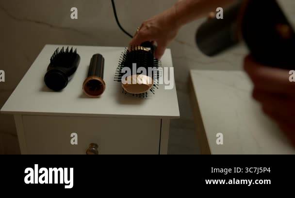 In a contemporary bathroom female hands are focused on attaching ...