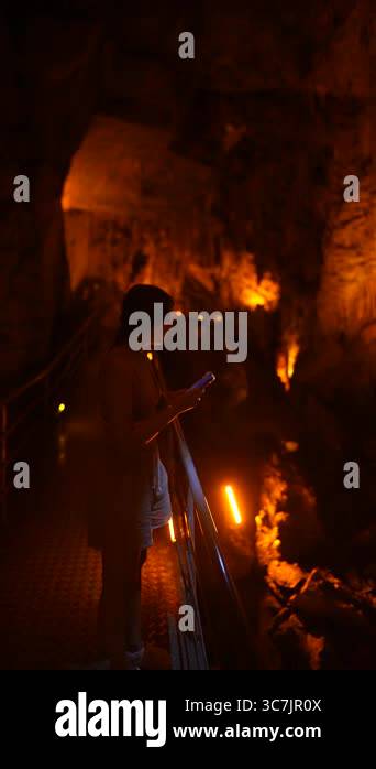 A curious person navigates a beautifully lit cave, showcasing stunning ...