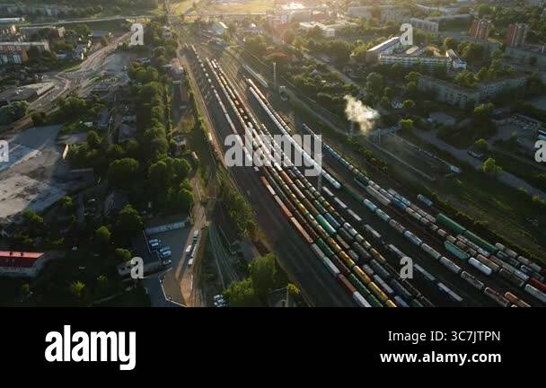 Freight trains with colorful containers fill a railway yard at sunset ...