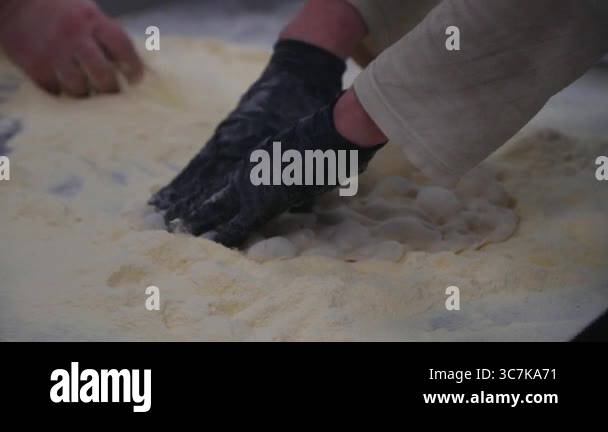 Baker working with dough. Hands kneading dough in flour, preparing it ...