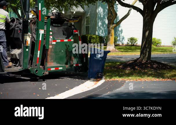 Garbage truck unloading a garbage can at sunny day. Middle shot. USA ...