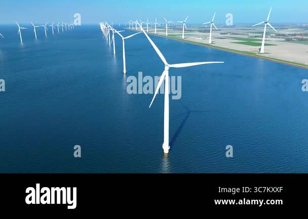 offshore wind turbines rotate gracefully over the serene waters of the ...
