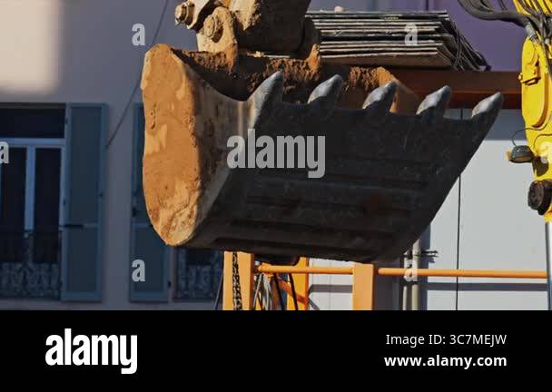Close up of a yellow crane machine moving and lifting on a construction ...