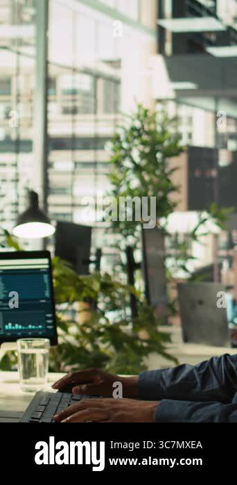 Vertical video Employee in office showing revenue figures on laptop to ...