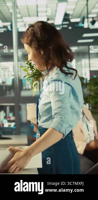 Vertical video Happy employee starting first day at new job, unpacking ...
