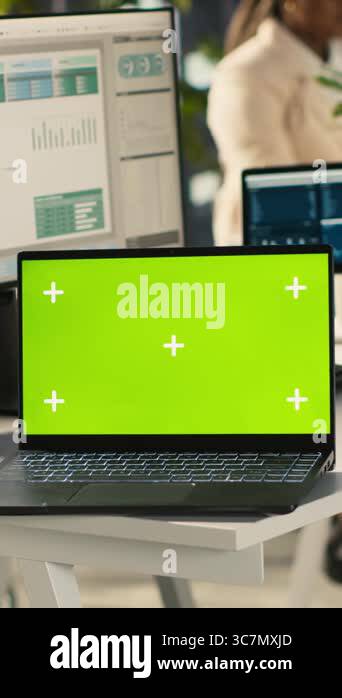 Vertical video Green screen laptop on office desk next to employee ...