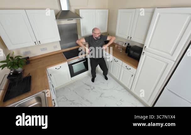 Man dancing in kitchen. Lighthearted person delighting in dancing spree ...