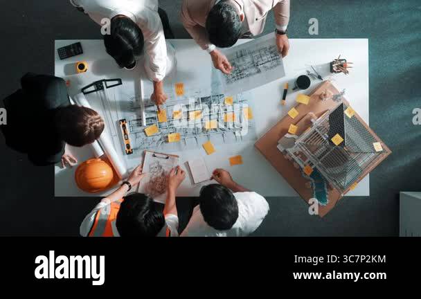 Top down view of skilled engineer team compare between blueprint and ...