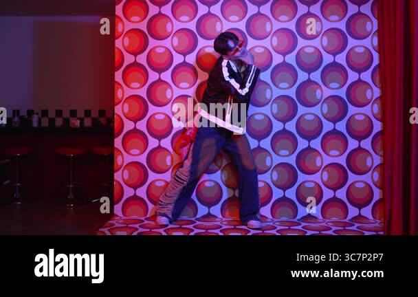 Asian break dancer moving to freestyle music and looking at camera at ...