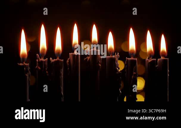 Nine candles burn on a dark festive background with a bokeh effect ...