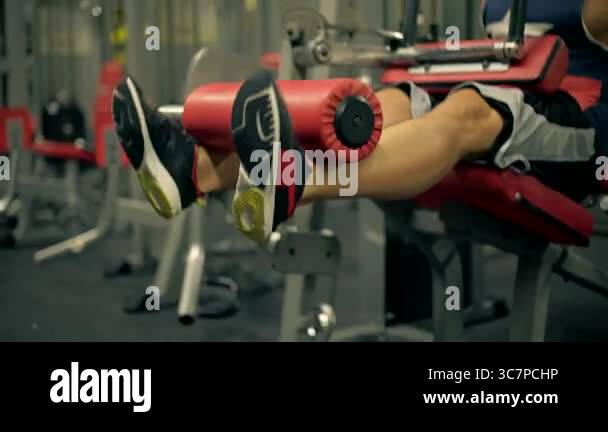 athletic man beard and bald head engages in leg exercises gym. He does ...