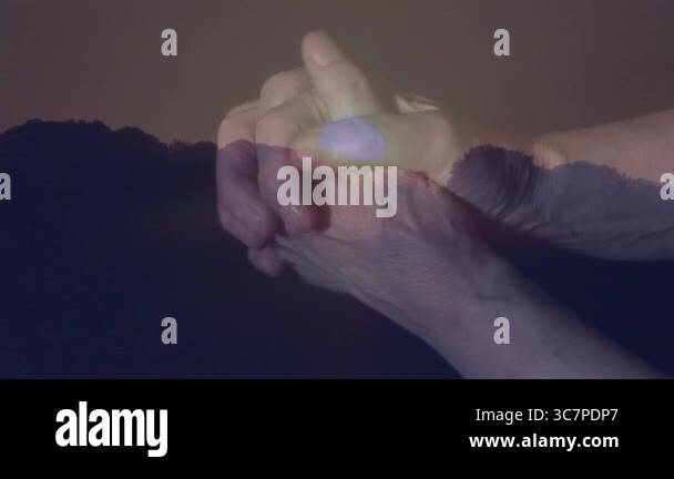 Clasping hands over mountain silhouette during sunset, creating ...