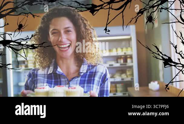 Smiling woman holding cupcakes with Halloween-themed spider web ...
